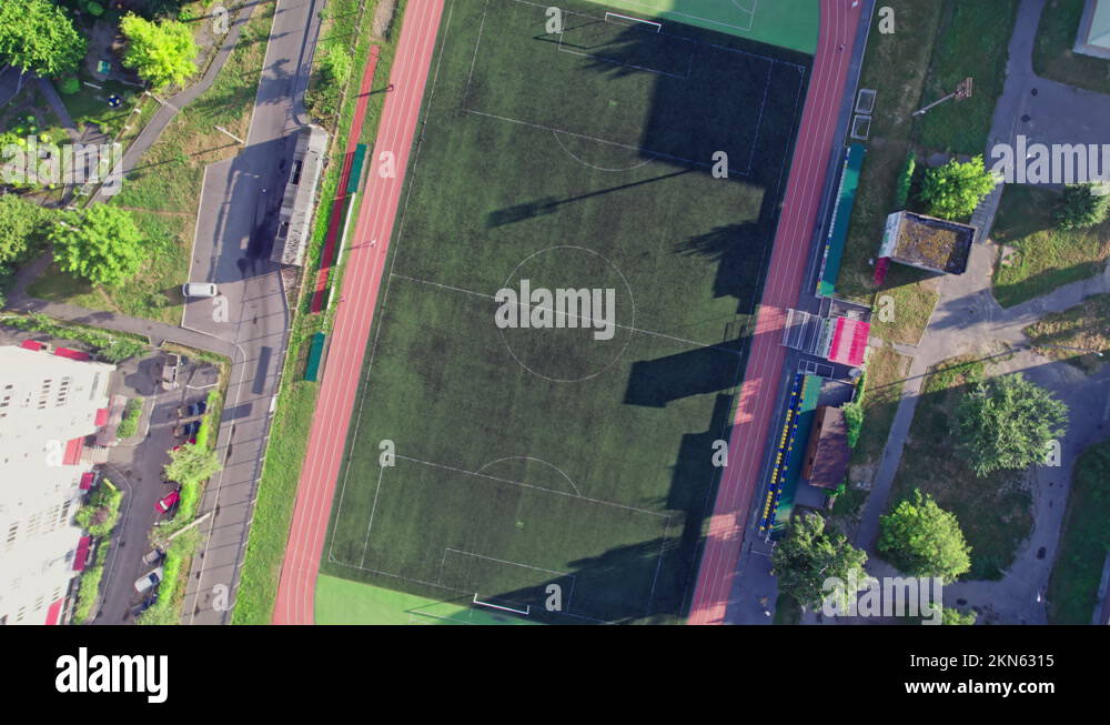 Buildings with street in small town with empty football soccer field ...