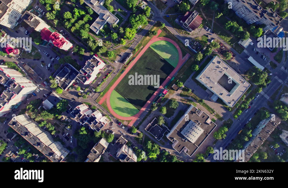 Buildings with street in small town with empty football soccer field ...