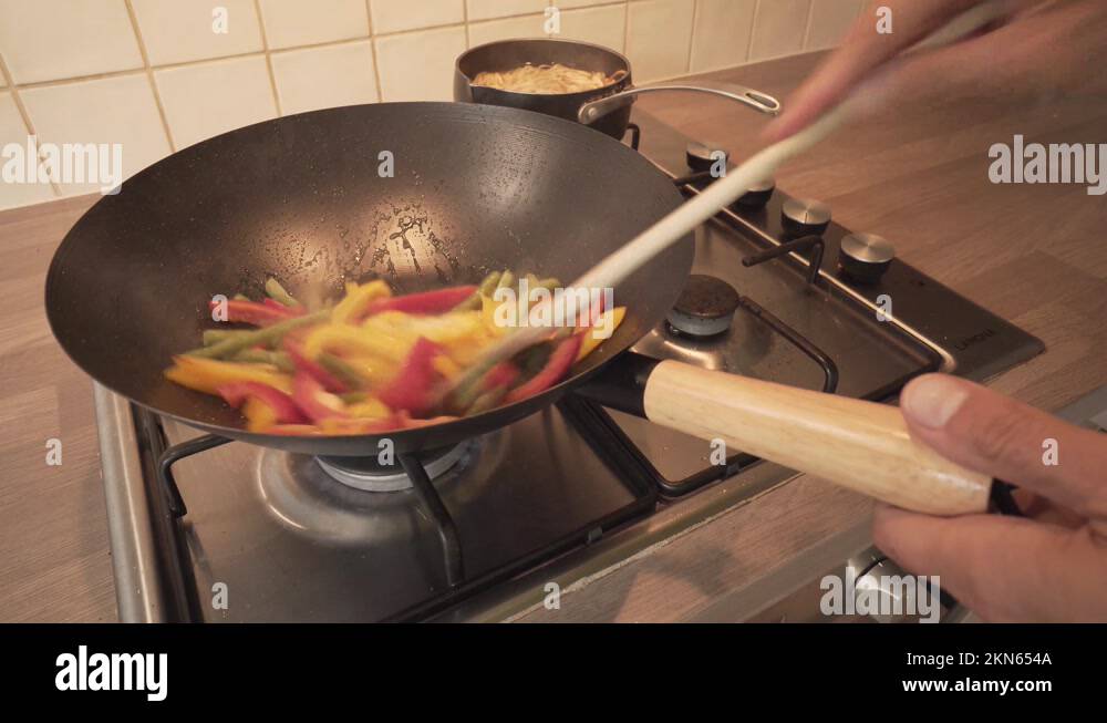 Man Mixing And Stir-Frying Green Beans With Bell Peppers On Non-Stick ...
