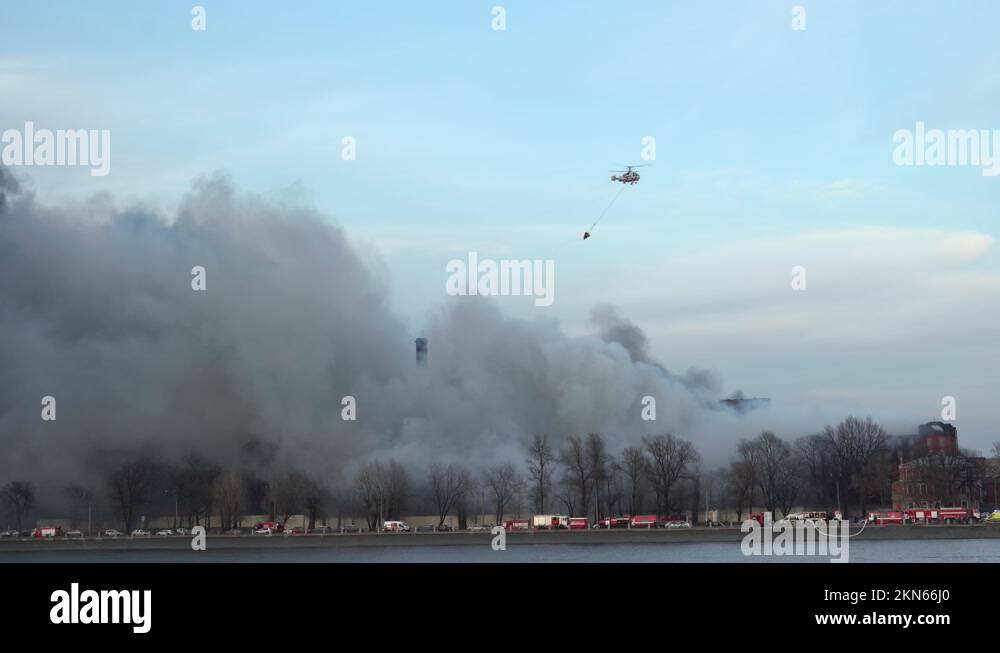 Helicopter extinguishes fire. Water from bambi bucket. Smoke. Fire ...