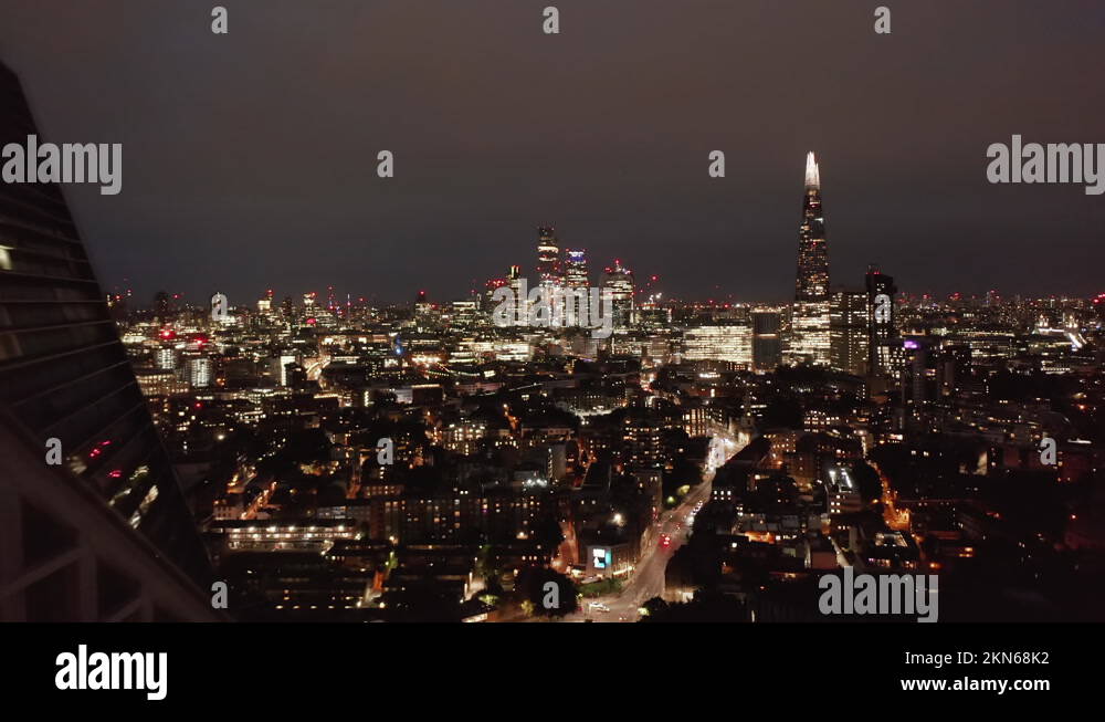Backwards reveal of top of high rise luxury apartment building. Night ...