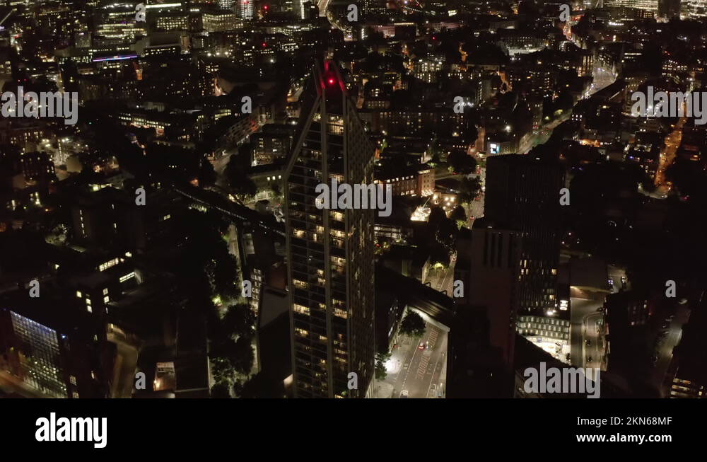 Tilt up revealing of tall modern apartment tower and night skyline in ...