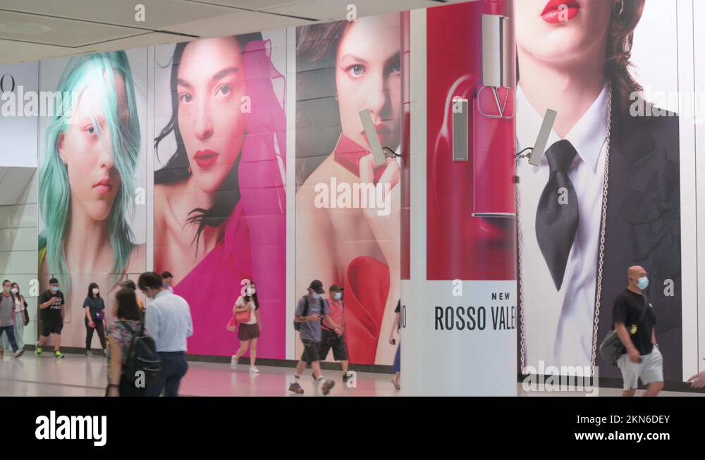 People walk past through a large commercial advertisement at Hong Kong ...