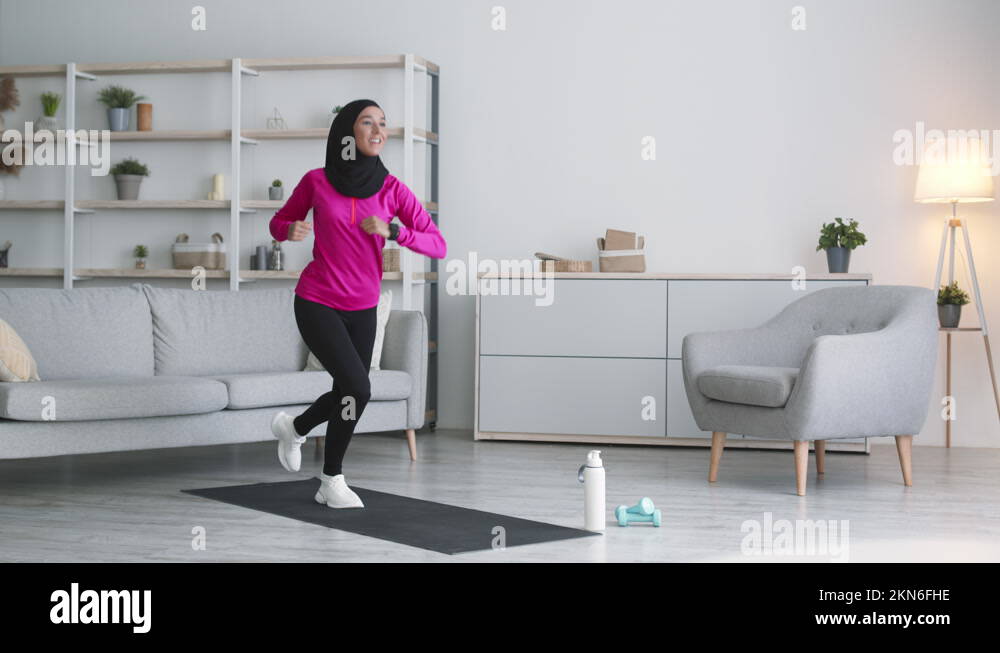 Dynamic fitness at home. Young happy muslim lady wearing hijab ...