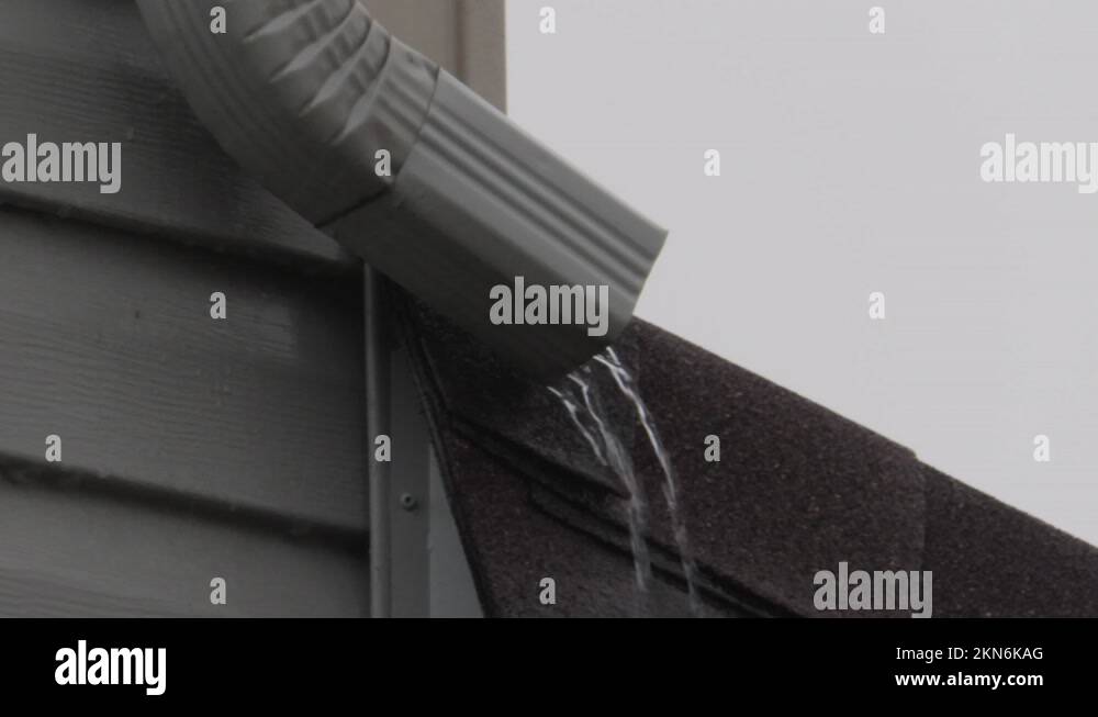 Rain downspout from gutter with water pouring out from second story to ...