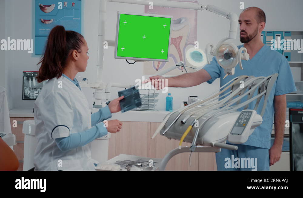 Dentist receiving teeth scan from man while looking at green screen ...