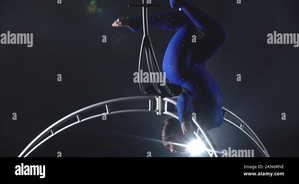 Gymnastics performance by a young woman in blue costume, upside down ...