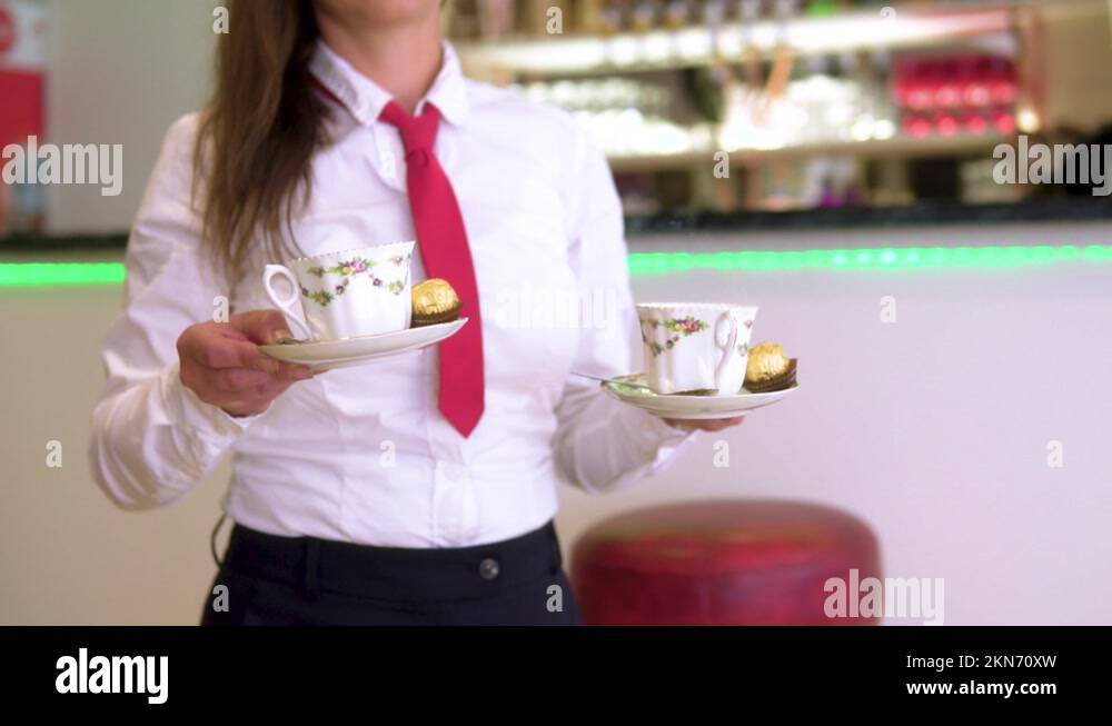 waitress in smart uniform wearing black pants white shirt and short red ...