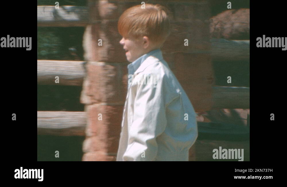 1960s: Film slate. Boy and girl walking in front of zoo exhibits. Boy ...