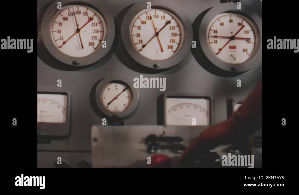 1950s: Gauges on machinery. Man adjusts dial and positions gauge. Men ...