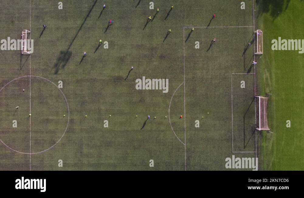 Top view of a drone taking aerial shots of kids playing soccer on a ...