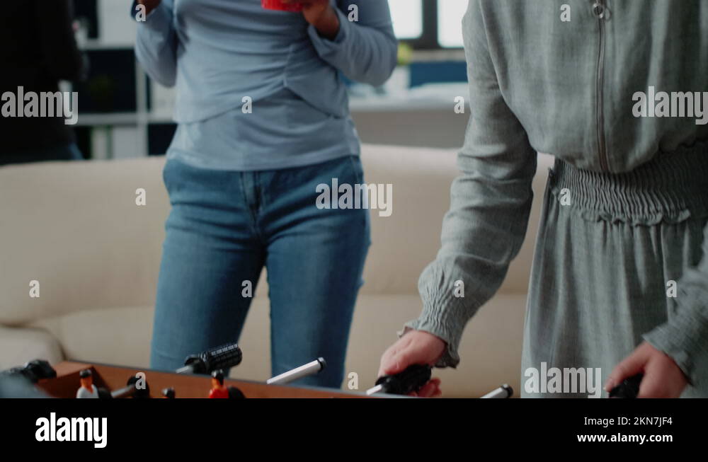 Close up of workmates using foosball table to do fun activity Stock ...