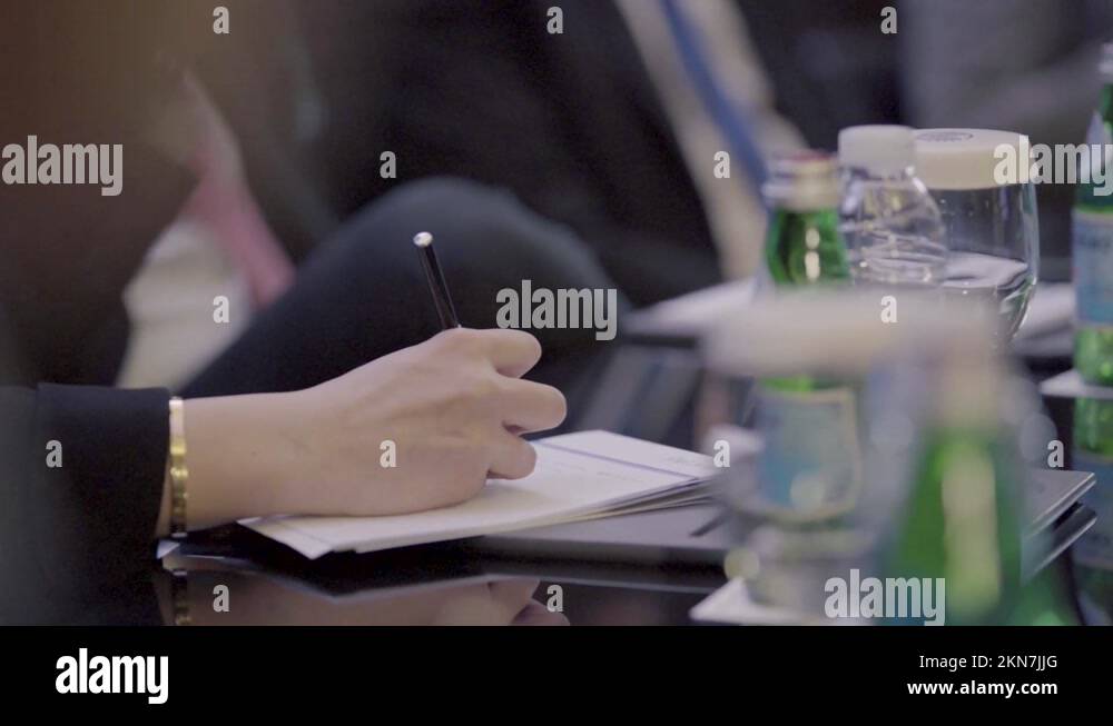 female writing notes on a small notepad in meeting room Stock Video ...