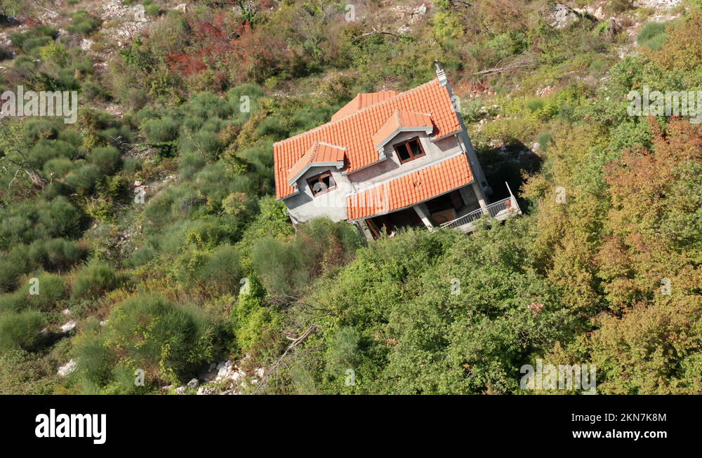 Leaning house after landslide on hillside - tilted building at inclined ...