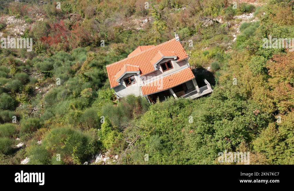 Crooked house after landslide on hillside - tilted building at inclined ...