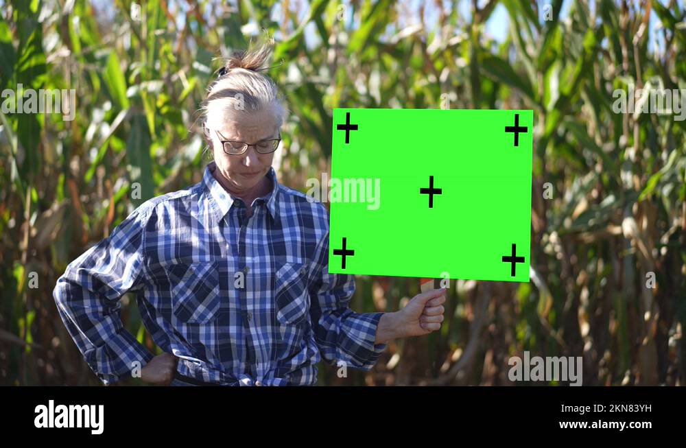 Sad, unhappy farmer woman holding green screen chroma key sign in front ...