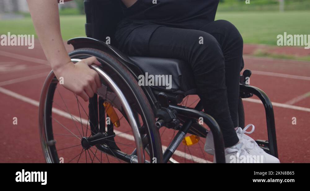 A female person with disabilities riding a wheelchair on a training ...