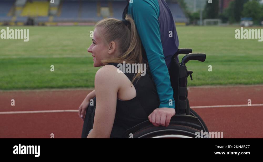A female person with disabilities riding a wheelchair on a athletics ...