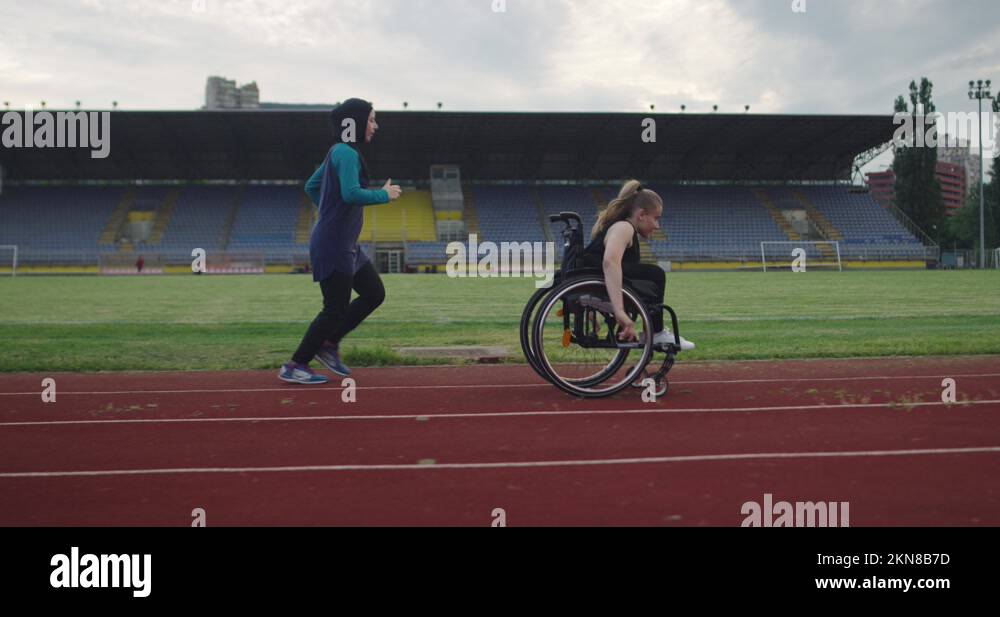 A female person with disabilities riding a wheelchair on a athletics ...