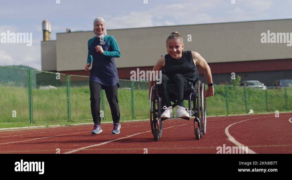 A female person with disabilities riding a wheelchair on a athletics ...