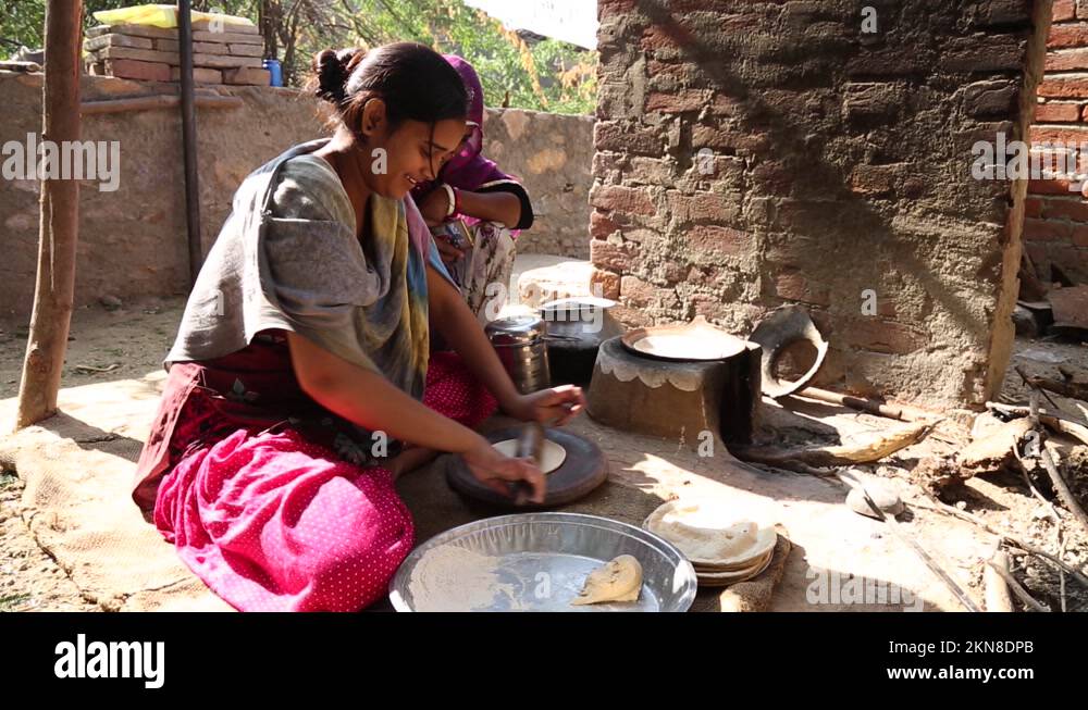 Domestic life of young Indian girls preparing traditional chapati bread ...