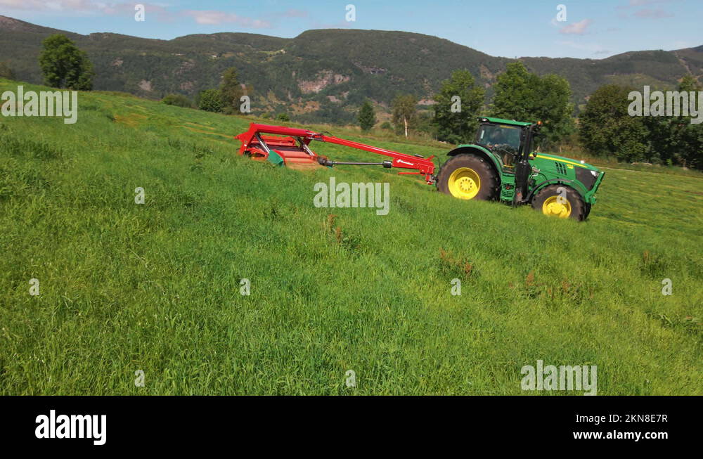 Tractor Dragging A Harvester In Green Field Overlooking Beautiful ...