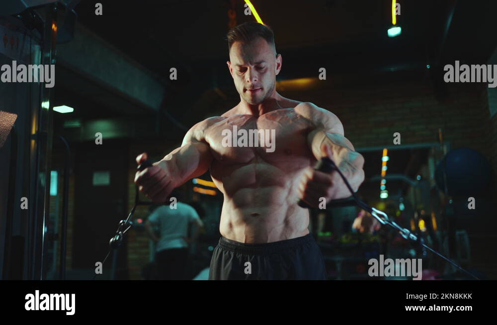 bodybuilder athlete with perfect torso exercising cable crossover ...