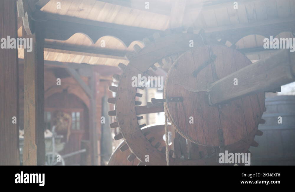 Wooden pulley gear and cog wheels of an old well in medieval courtyard ...