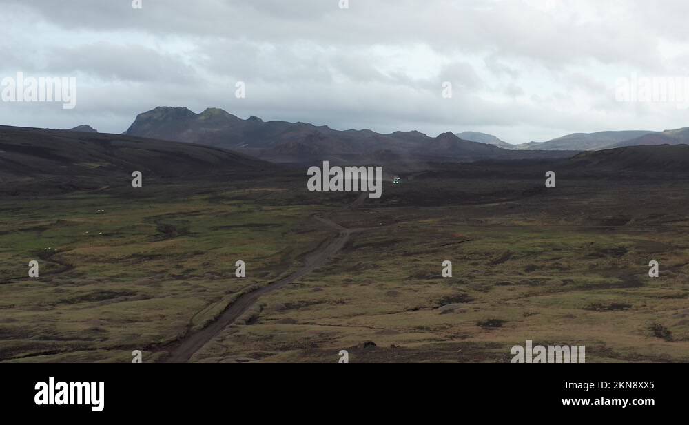 A bus moving towards the camera creating a dust cloud in a moody epic ...