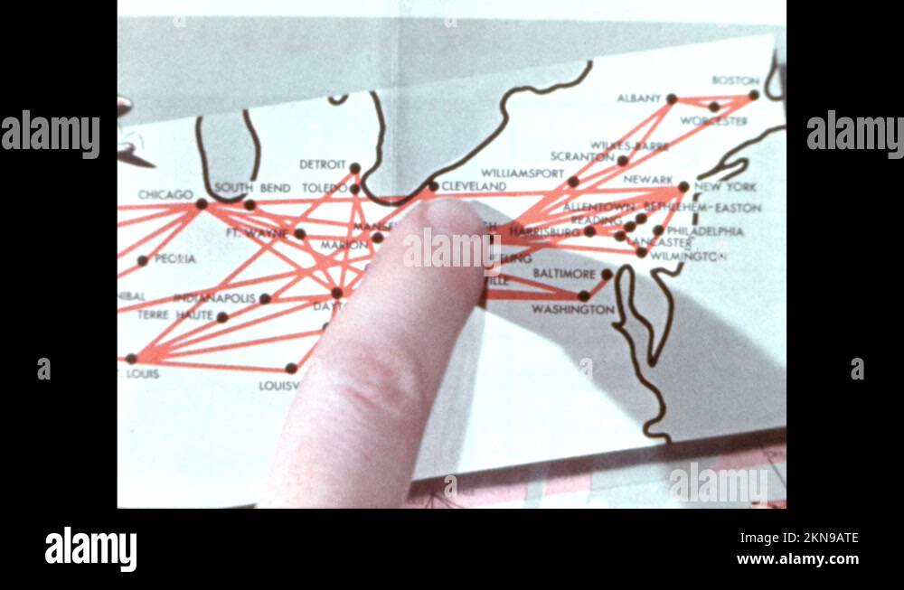 1950s: Finger traces plane route on flight map. Boys talk and look at ...