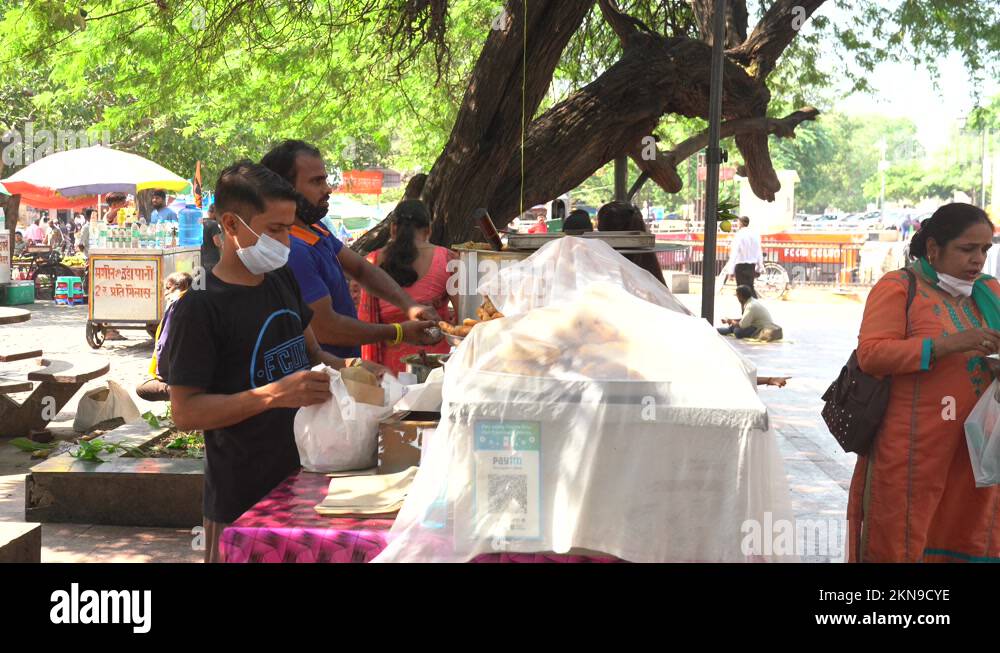 Static shot of a street food seller and people outside Hanuman Mandir ...