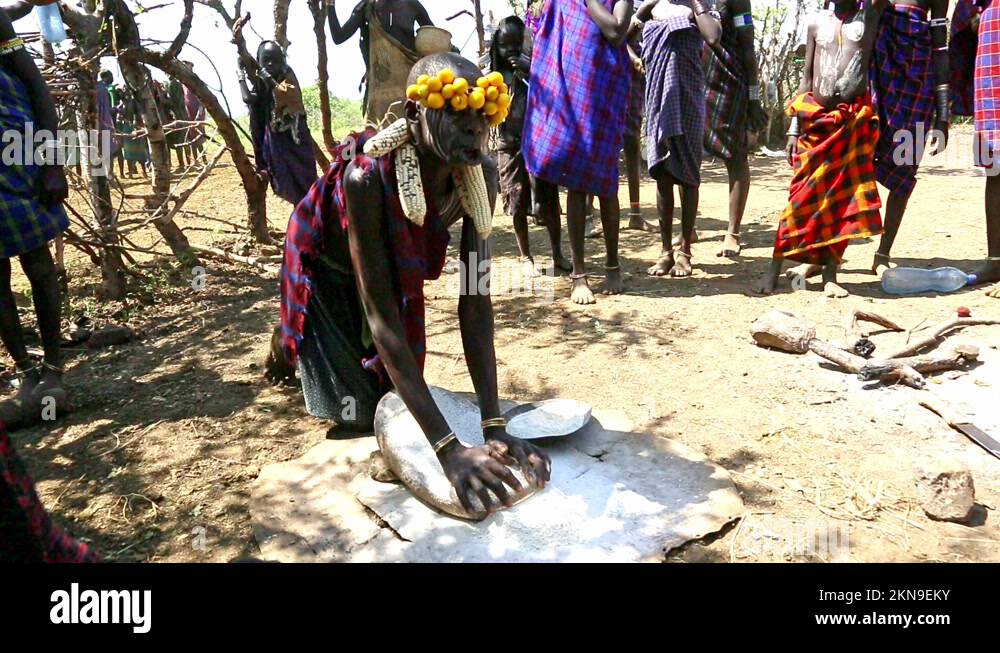 Mursi woman grinding corn with a millstone Omo valley, Ethiopia Stock ...