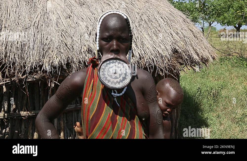 Morsy woman with traditional lip plate, and a baby on her back Stock ...