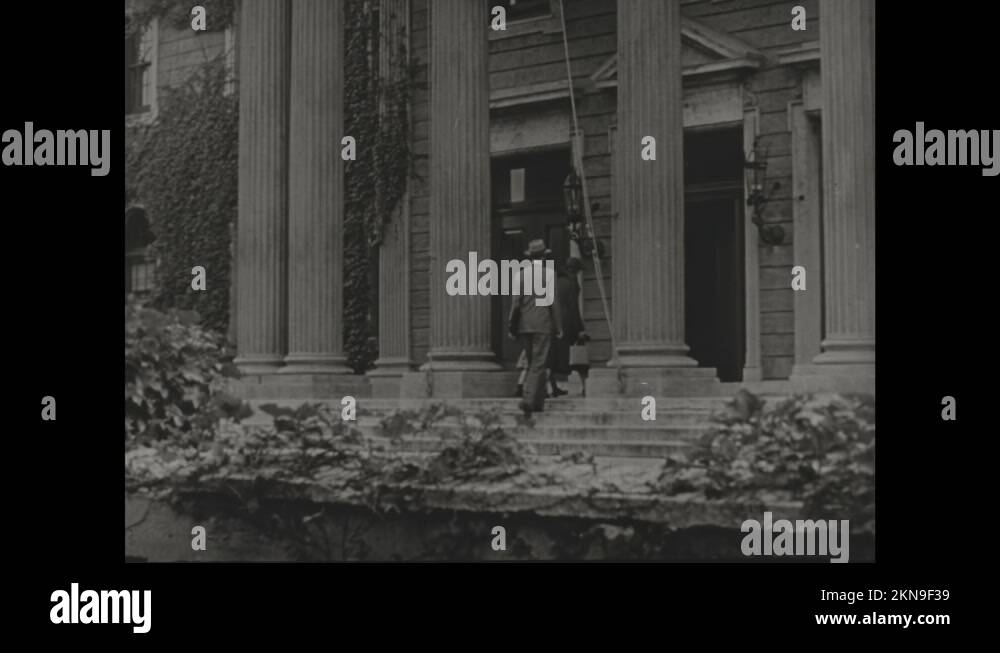 1940s: People walking up steps to building. Car stops, officer and boy ...