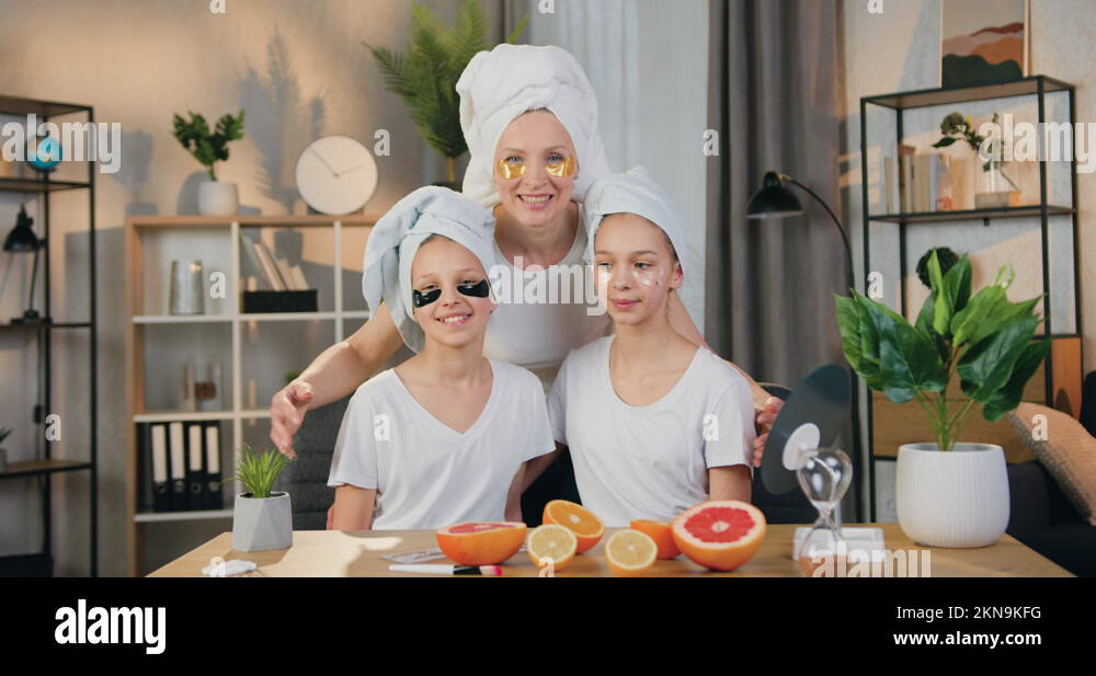 Attractive happy loving mother hugging her two teen daughters which ...