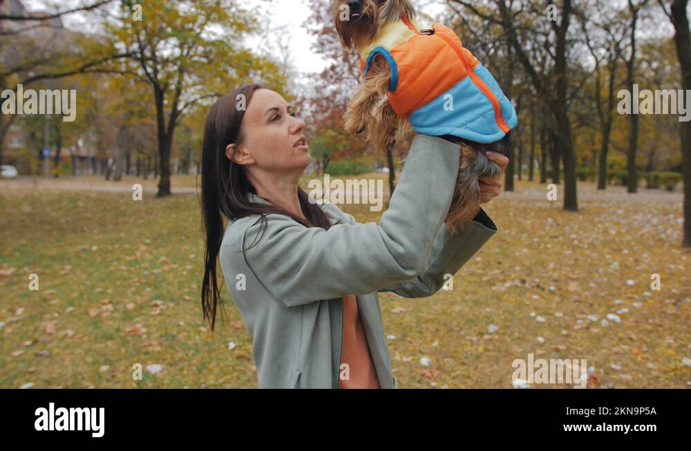 A woman with a teenage daughter having fun with a small dog throwing ...