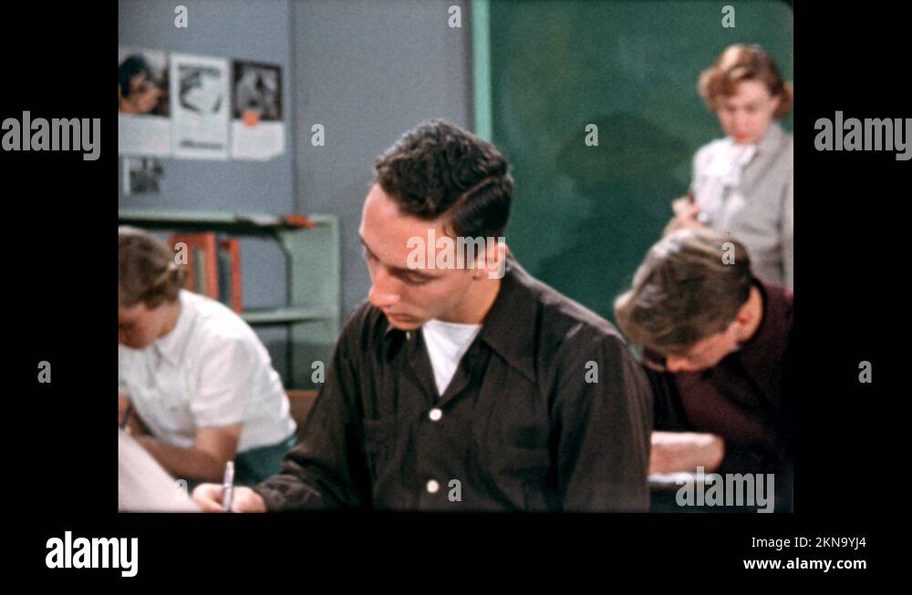 1950s: Question on test highlighted. Students writing test, teacher ...