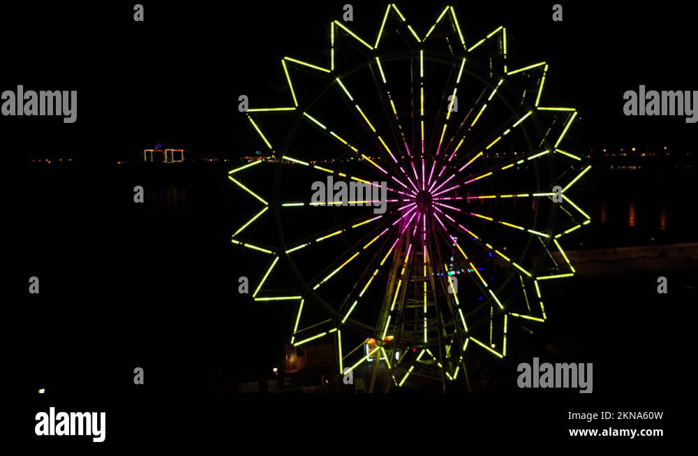 Ferris Wheel Flashes Neon Lights in Night Darkness. Park. Promenade ... Ferris Wheel Flashes Neon Lights in Night Darkness. Park. Promenade ...