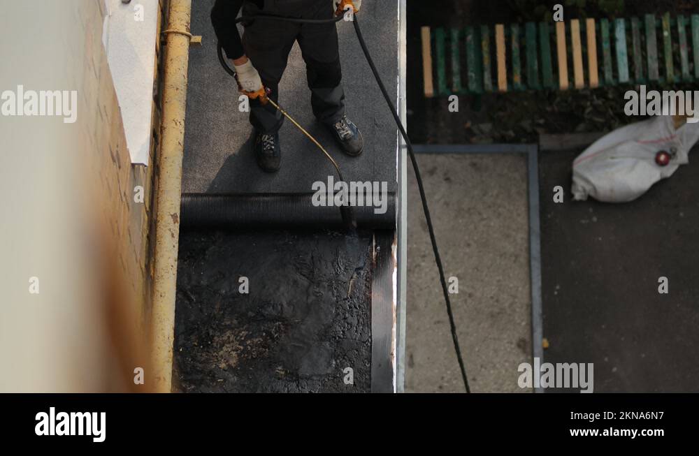 employee melt bitumen gas burner repairs the roof of the house Stock ...