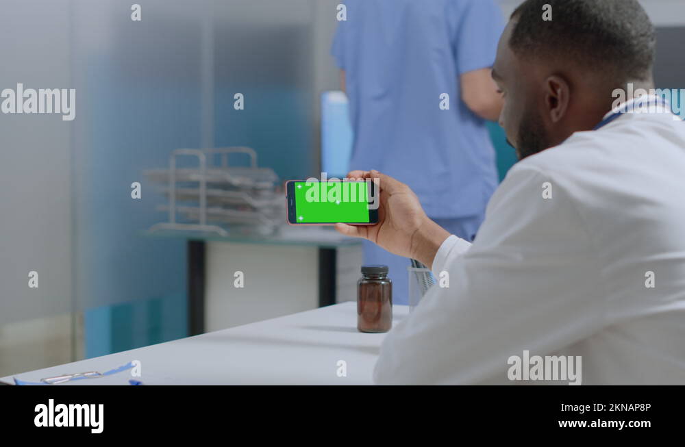 African american specialist doctor looking at mock up green screen ...