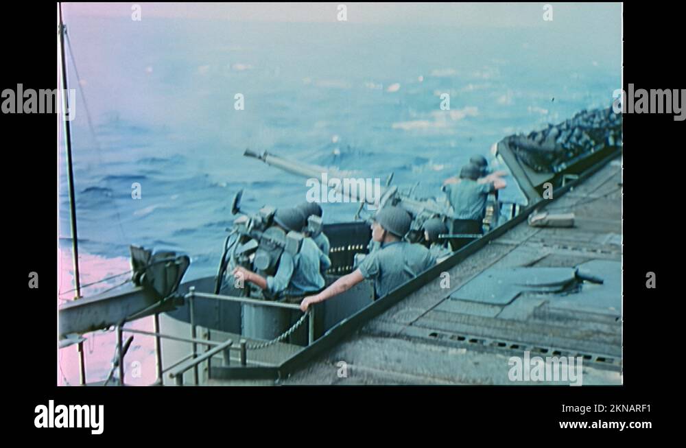 1940s: Iwo Jima island and naval battle. Guns fire off of boats. Shells ...