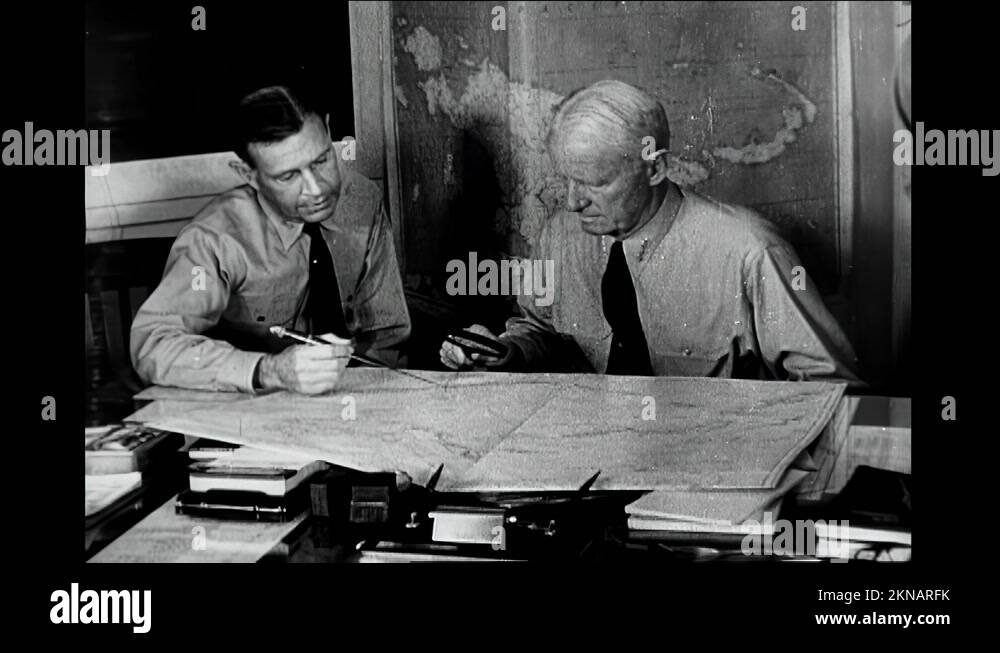 1940s: Text and lines appear on animated map. Men in meeting. Men look ...