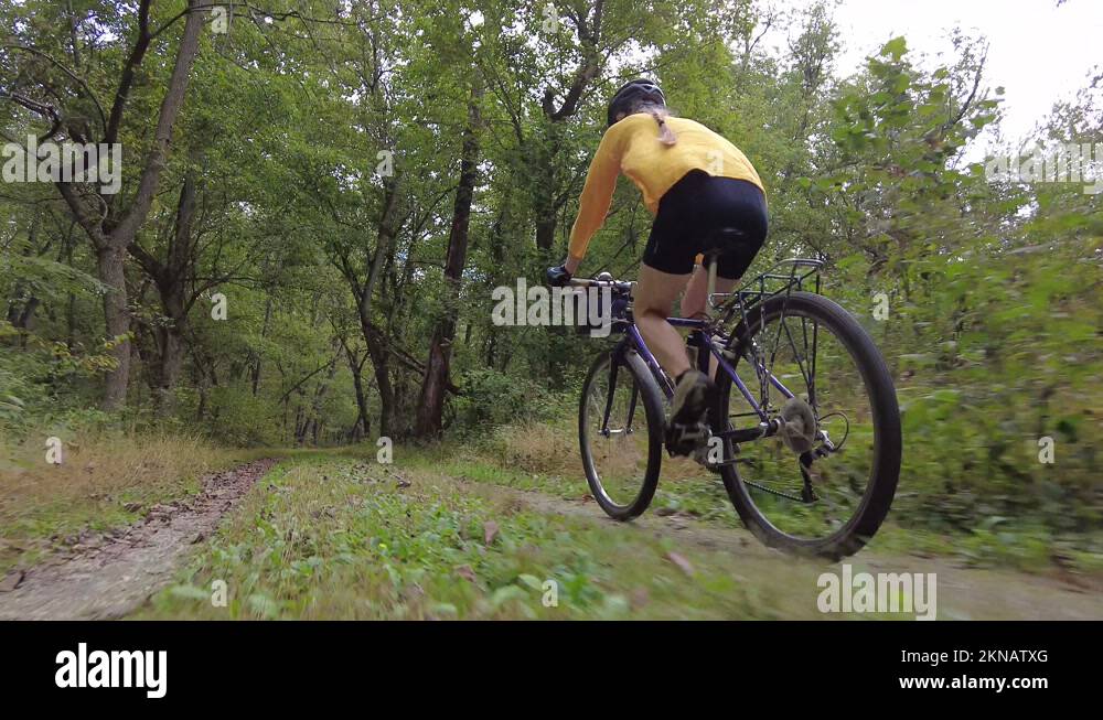 Low angle looking up at woman with freedom, biking on a cycle path in ...