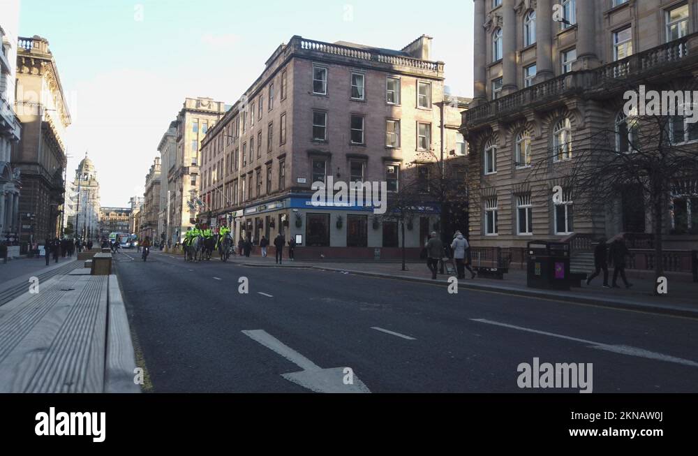 A group of police officers and their horses coming down a city road ...