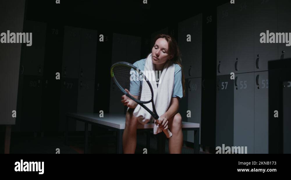Young woman tennis player is resting in the locker room after the match ...