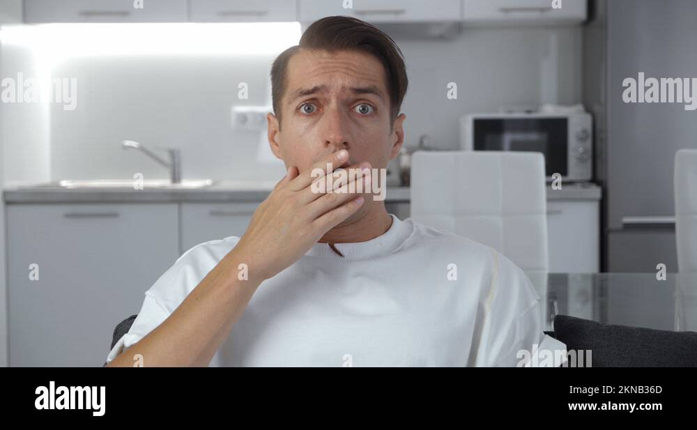 Close-up portrait of scared man bulging eyes and covering mouth in ...