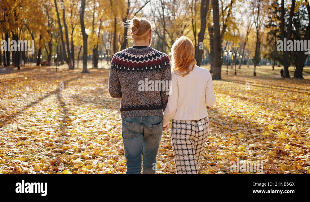 Back view of unrecognizable young boyfriend and girlfriend walking in ...