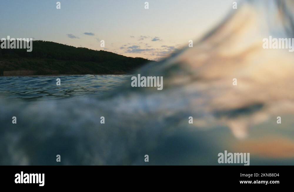 Extreme low angle sea-level view moving forward on sea water surface at ...