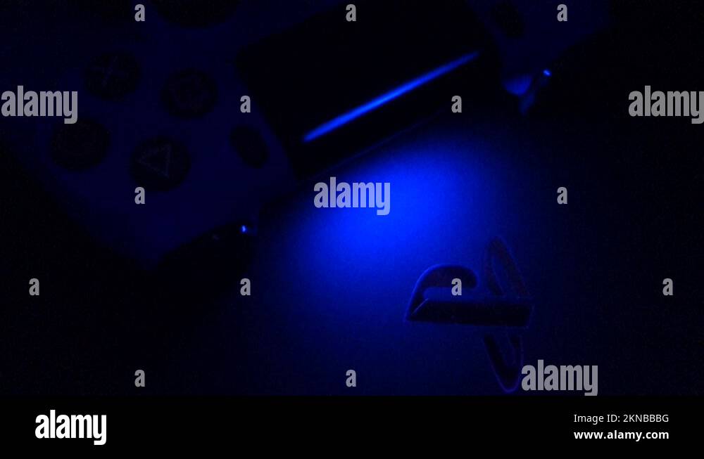 Sony Playstation logo lit on neon blue light from game controller, dark ...