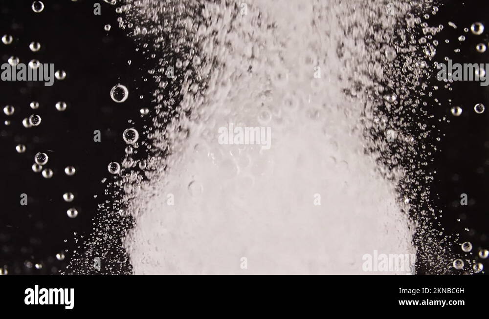 Effervescent tablet aspirin. Pill falling down in water on black ...